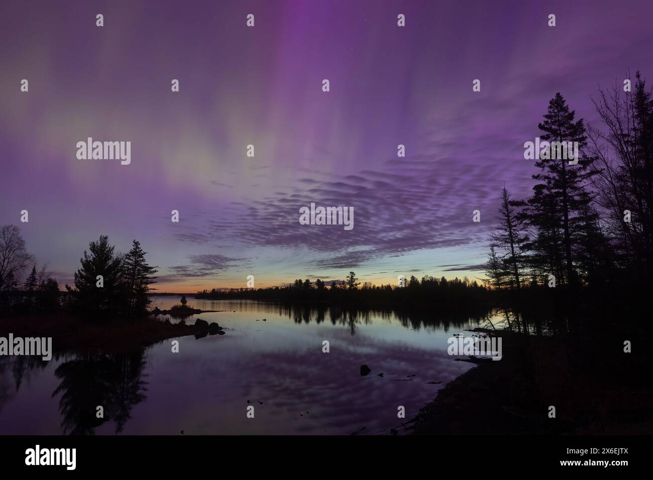 Northern lights glow over a lake in Minnesota in as the dawn on the ...