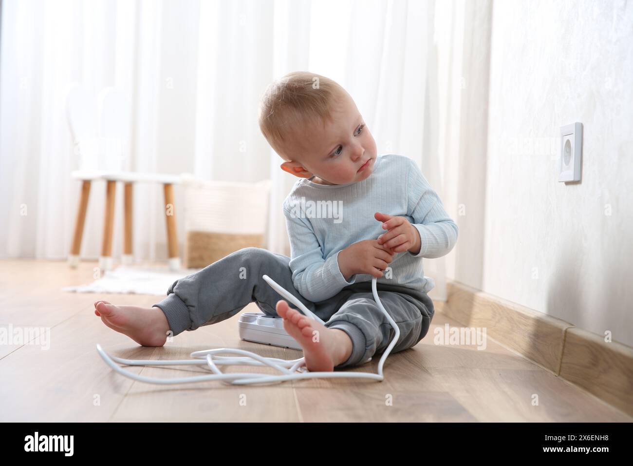 Little child playing with power strip plug near electrical socket at ...