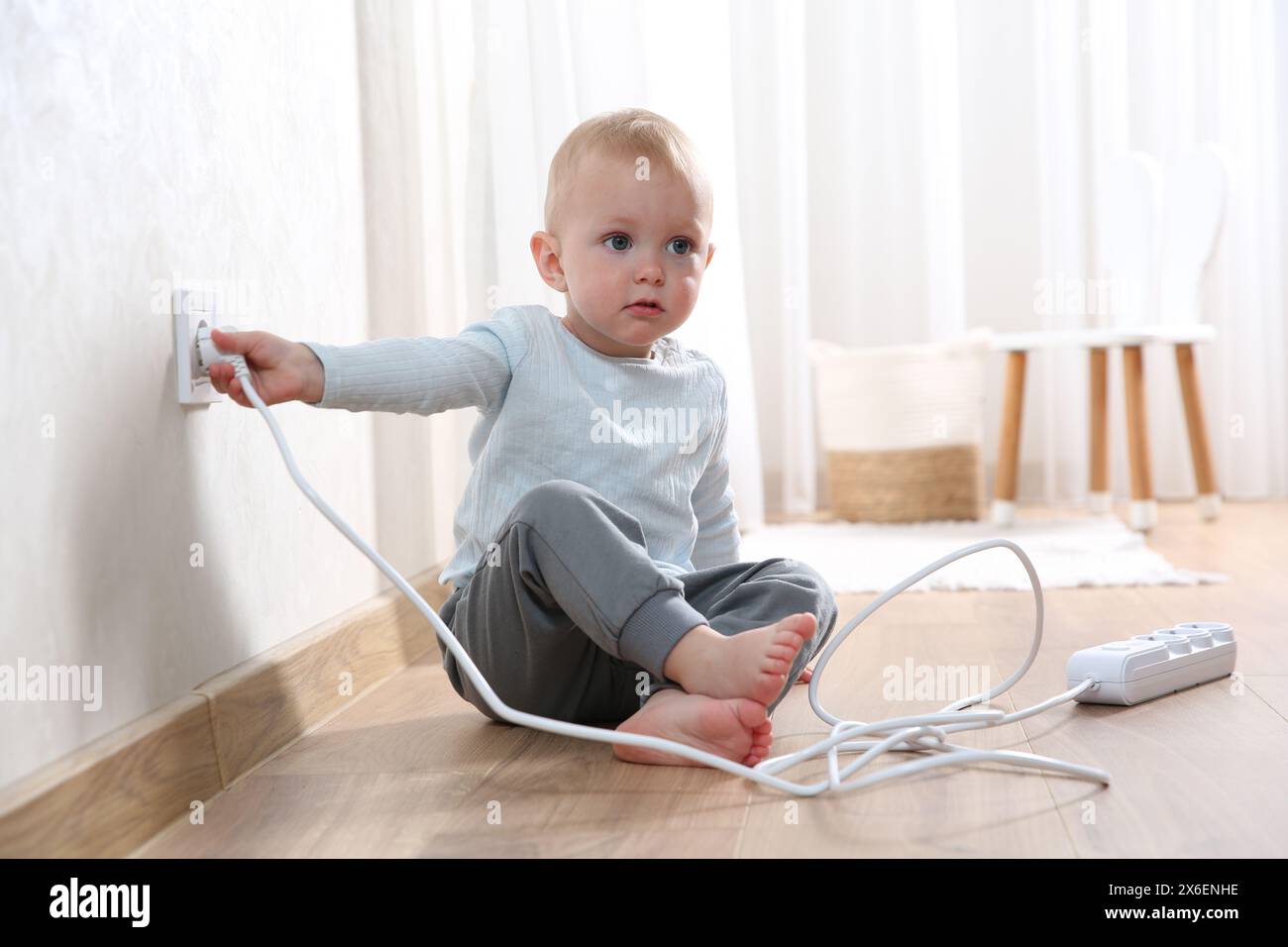 Little child playing with electrical socket and power strip plug at ...