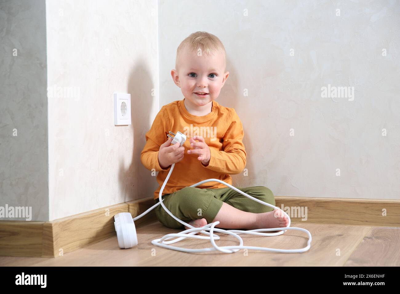 Little child playing with power strip plug near electrical socket at ...
