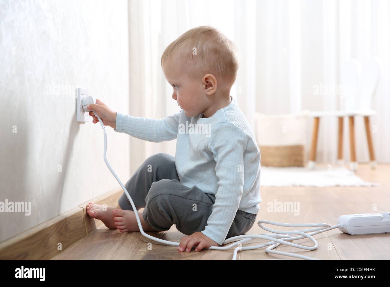 Little child playing with electrical socket and power strip plug at ...