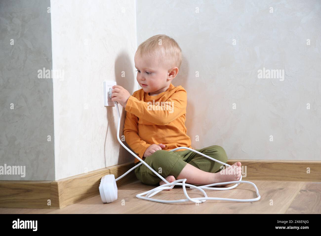 Little child playing with electrical socket and power strip plug at ...