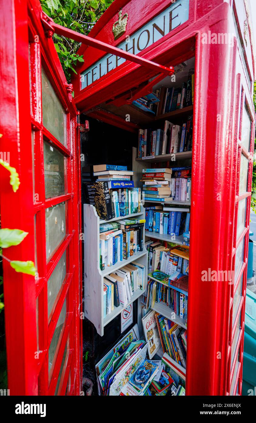 A traditional red telephone box disused for telephony now used as a ...