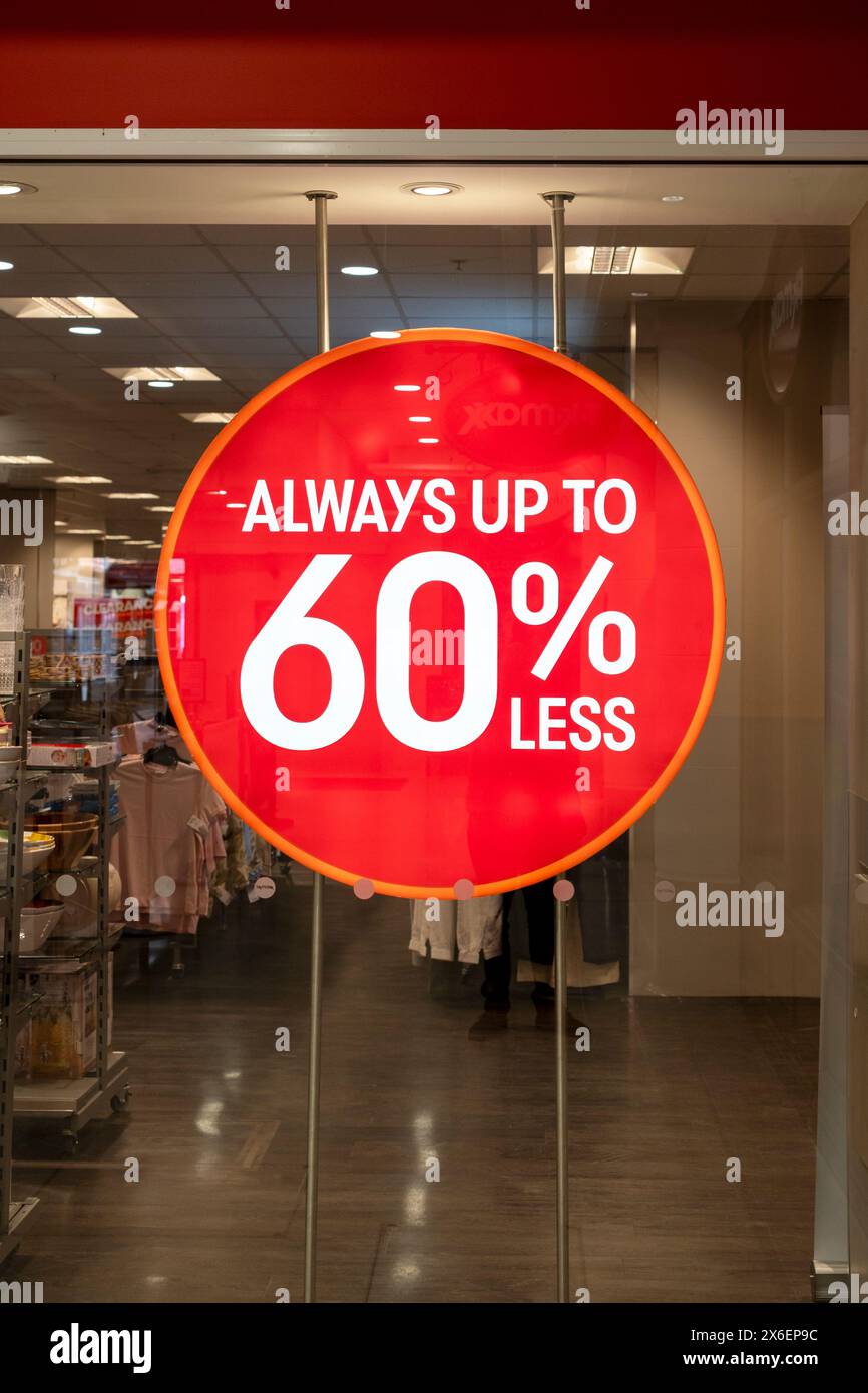 Round red 60% less sign in shop window Stock Photo - Alamy