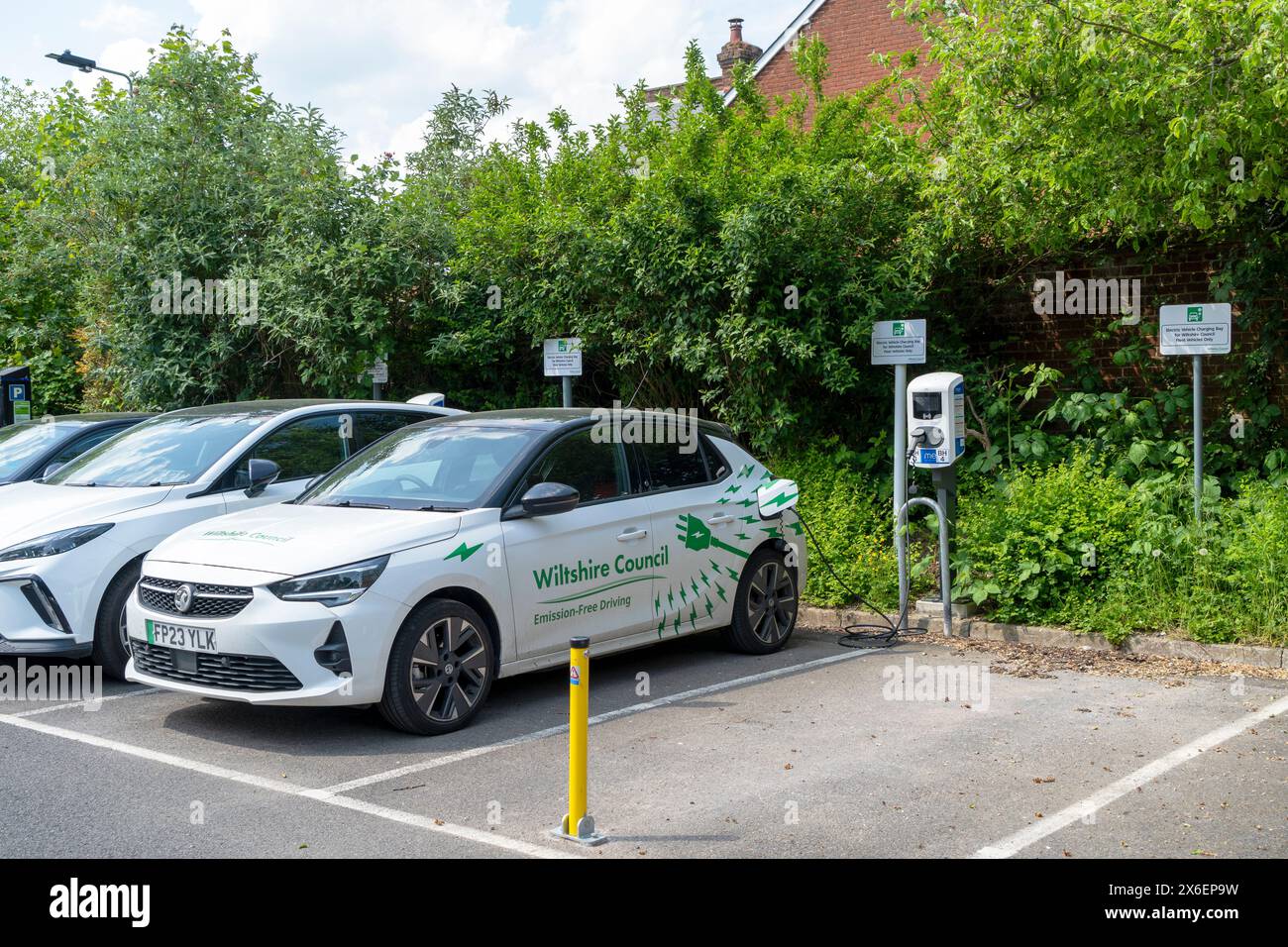 Electric car connected to charging unit Stock Photo - Alamy