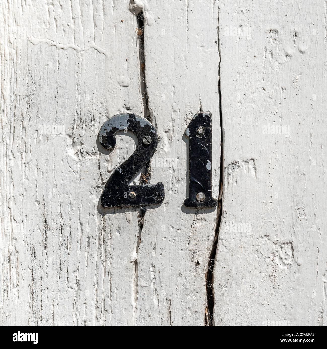 Number 21 attached to an old white painted cracked wood surface Stock ...