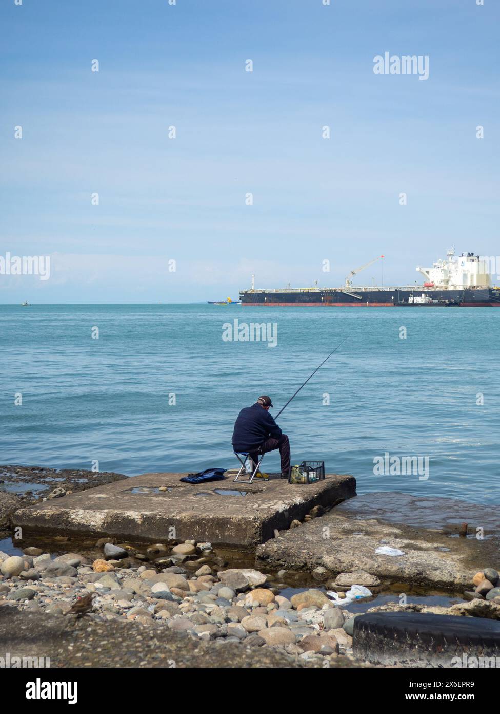atmosphere of a seaport. Pier at the cargo port. People relax on the ...