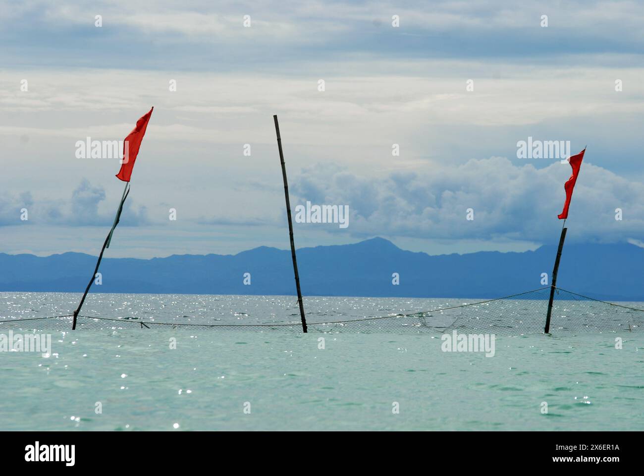 Poles with red flag to indicate position of fishing pots. Piagao ...