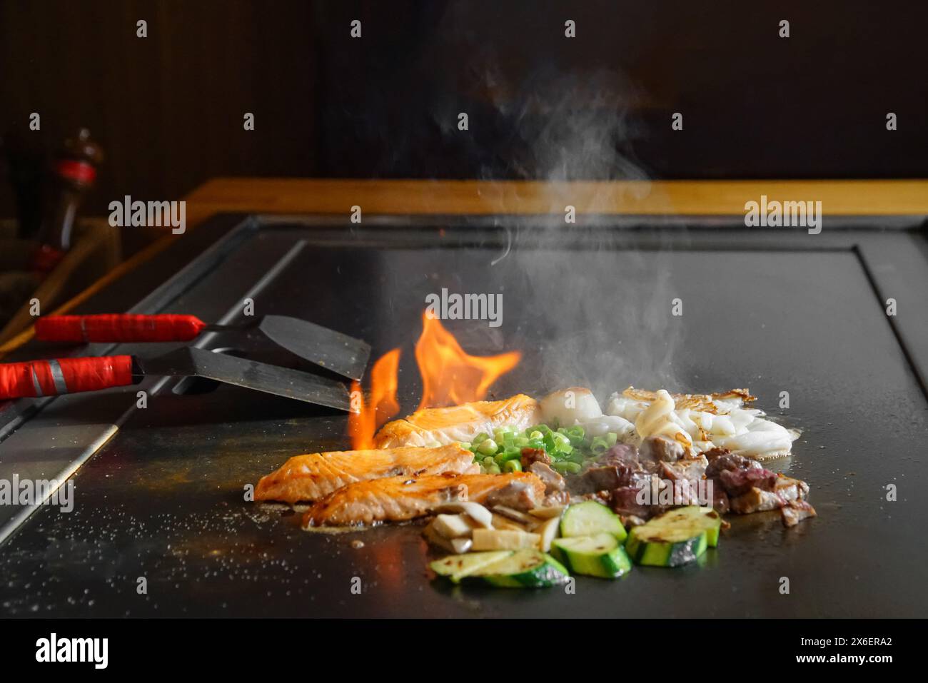 chef's hands with spatula over teppanyaki. cooking vegetables meat and ...
