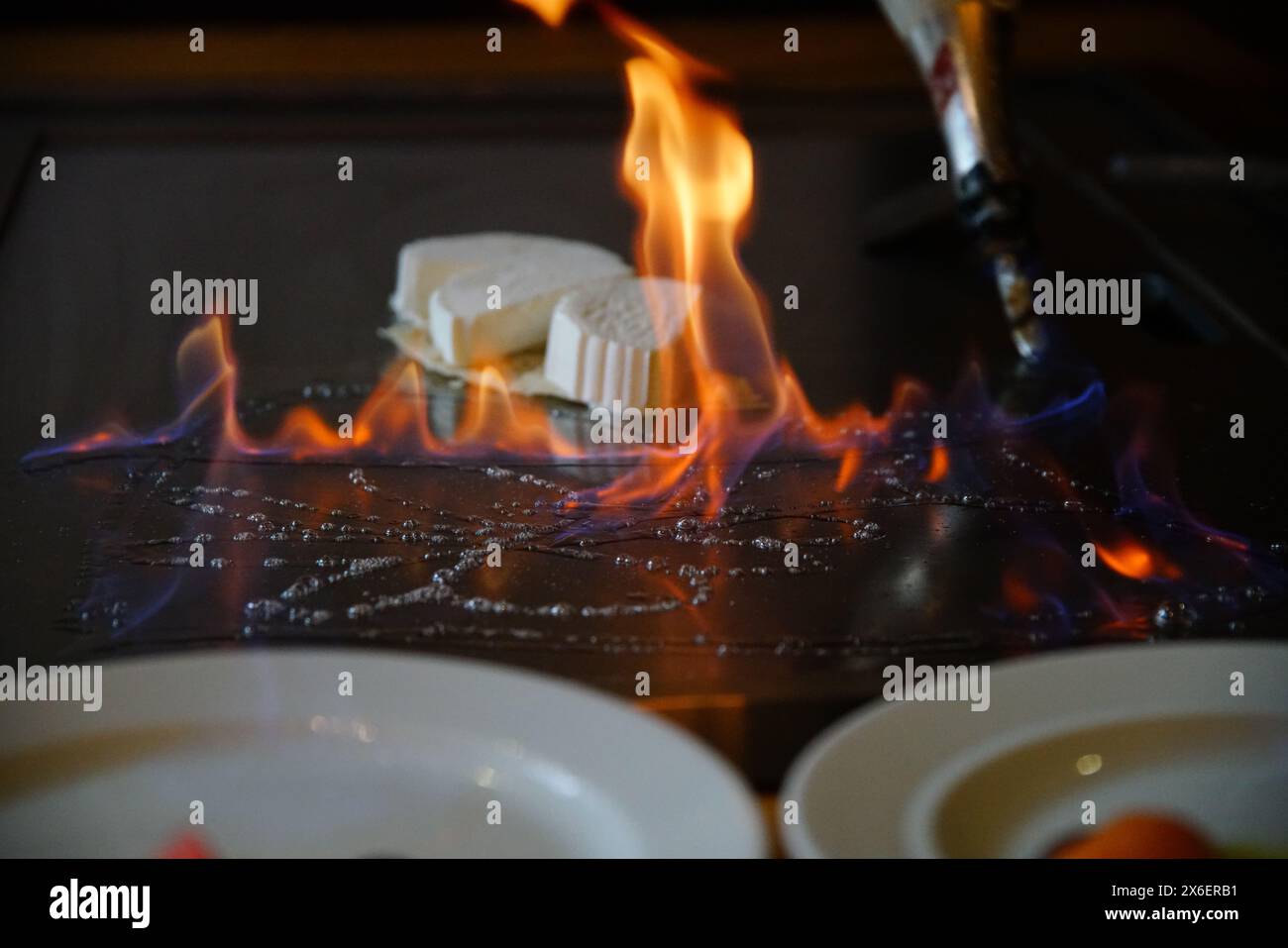 chef's hands with spatula over teppanyaki. cooking vegetables meat and ...