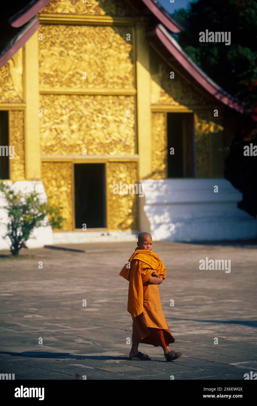 Monk walking past door with golden detail of deities, Royal funeral ...