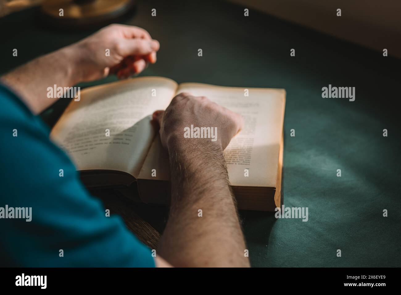 Books and reading. Reader behind an open book. mans hands turning the ...