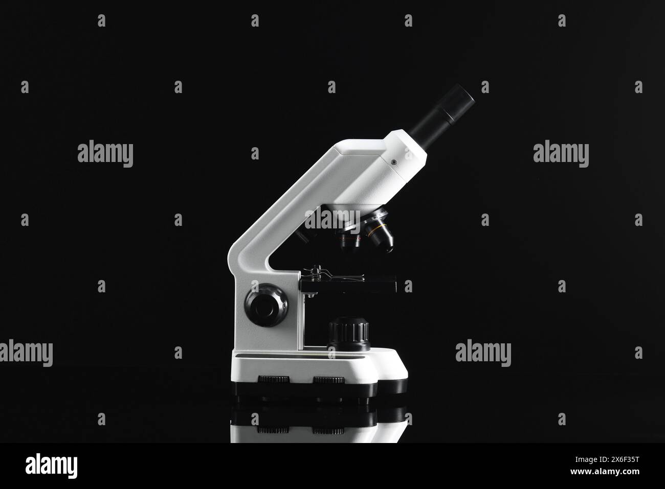 Modern metal microscope on black mirror surface Stock Photo - Alamy