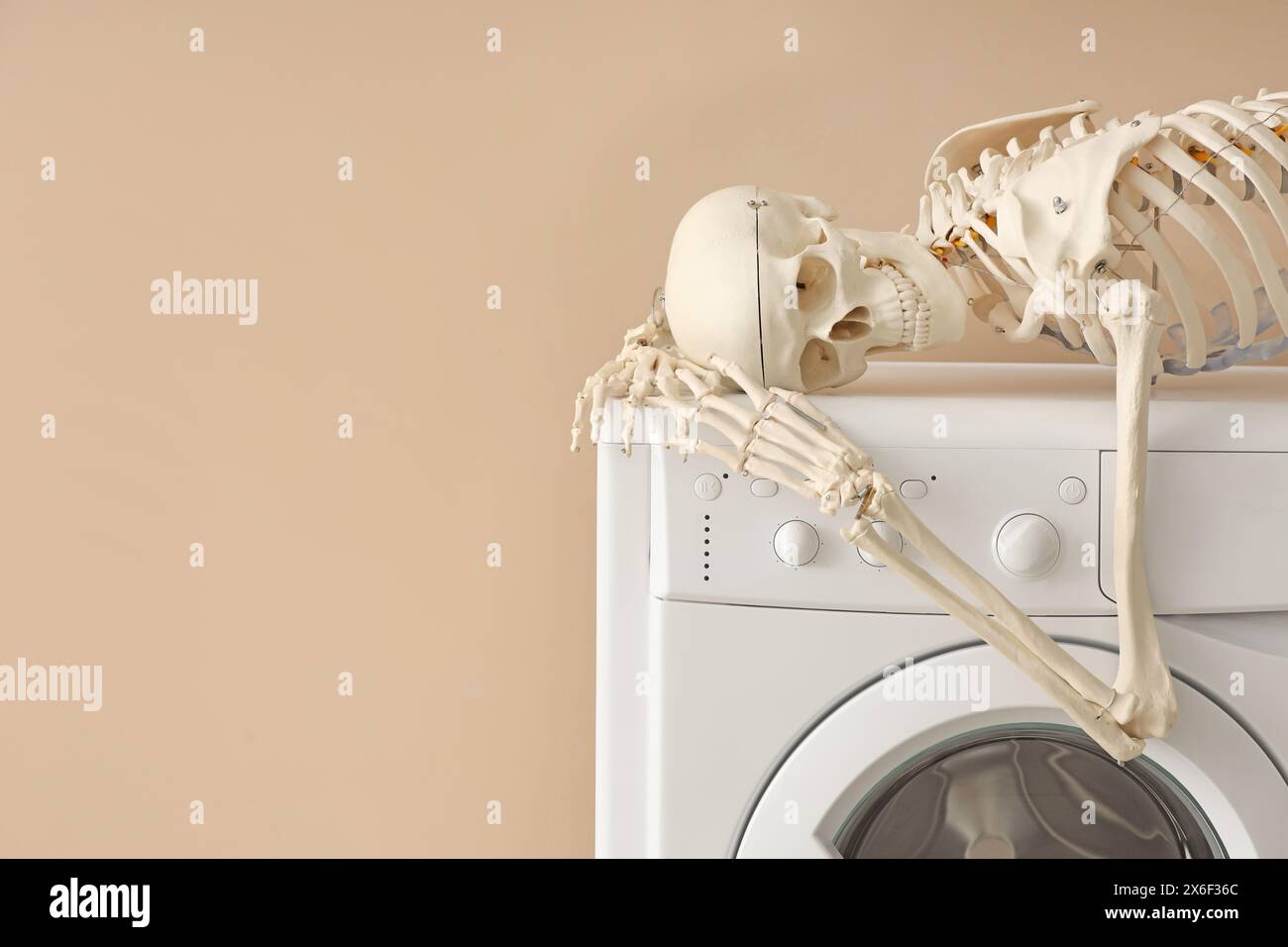 Waiting concept. Human skeleton lying on washing machine near beige ...