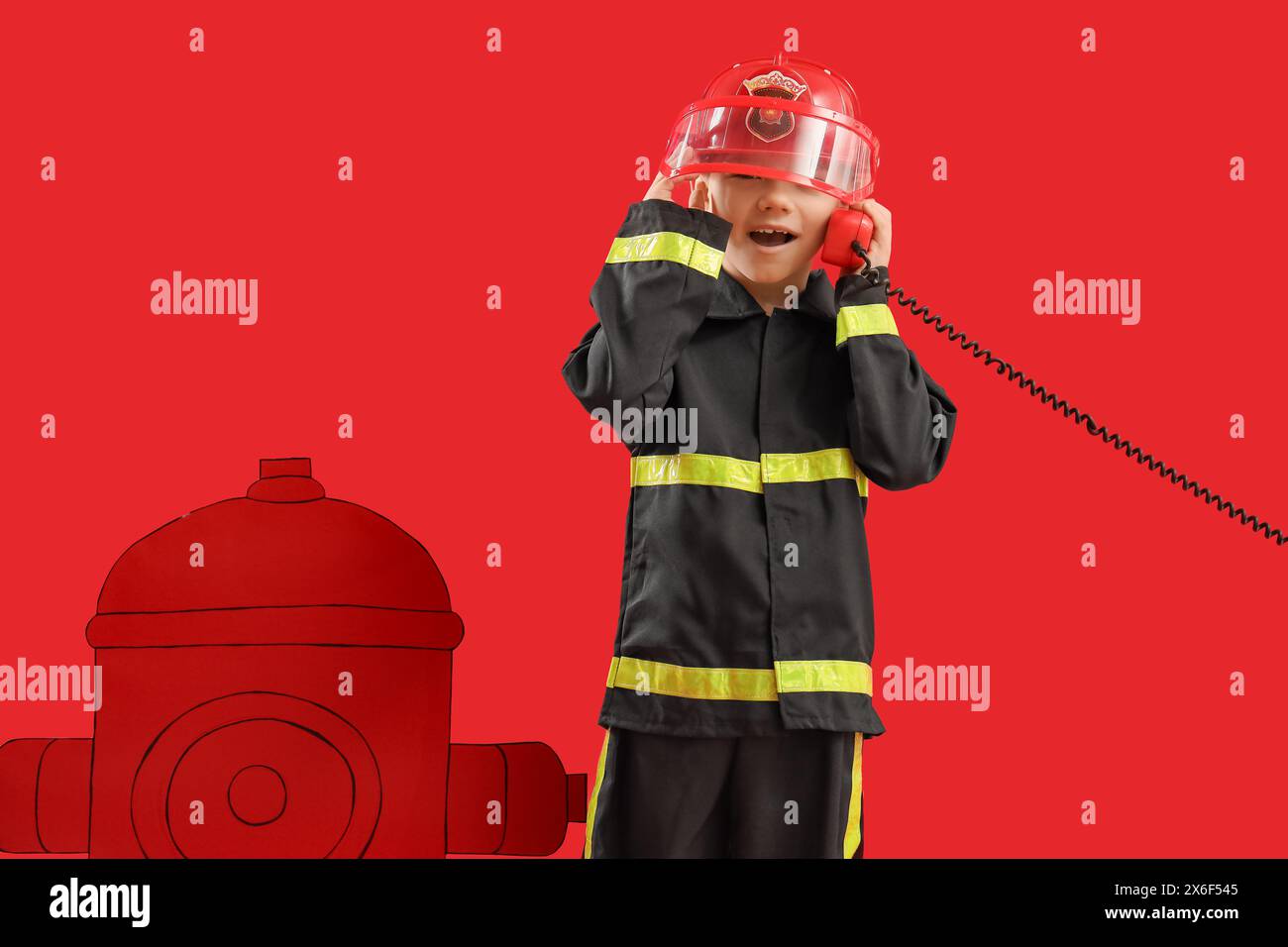 Cute little firefighter with paper hydrant talking by telephone on red ...