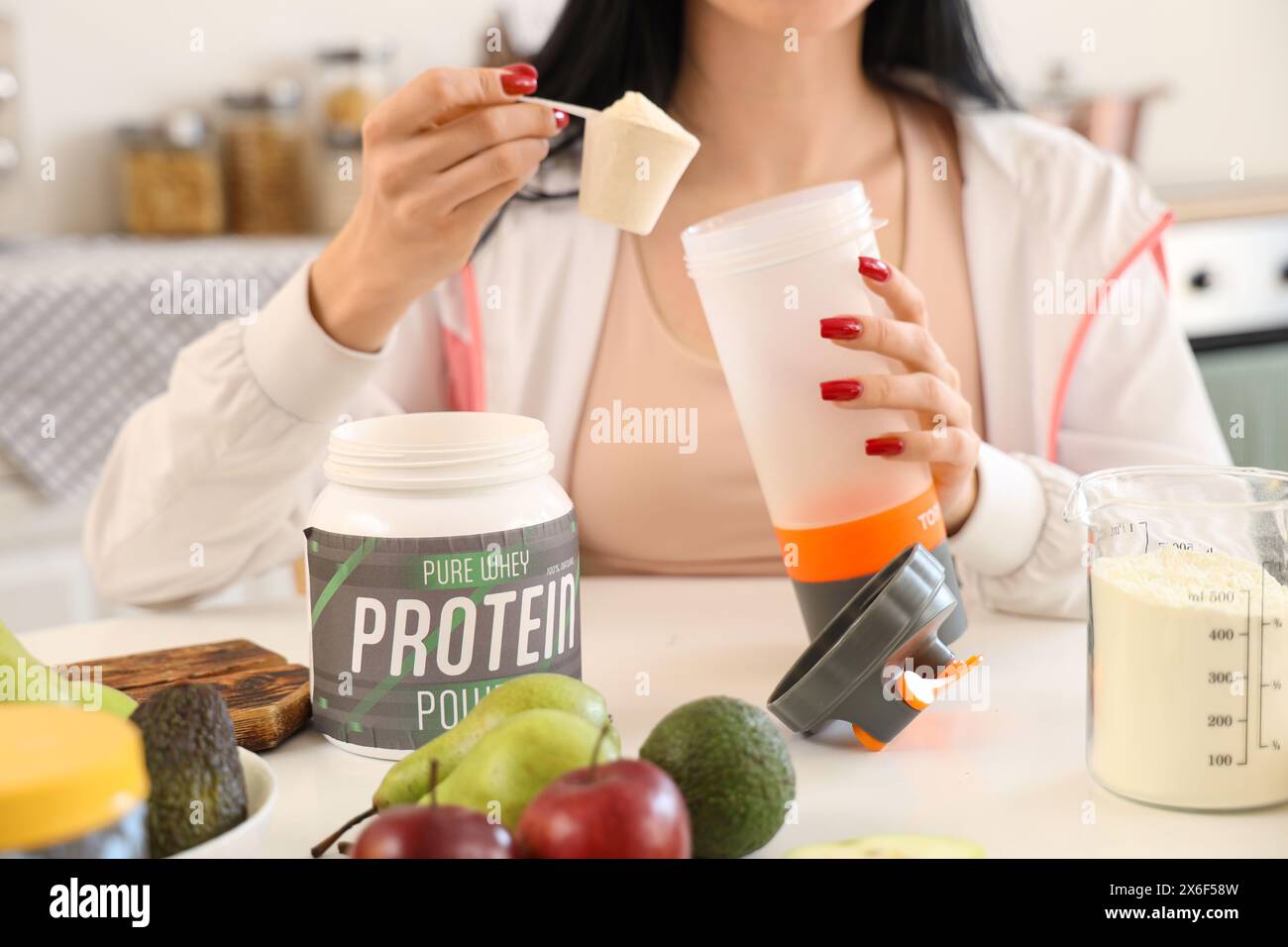 Sporty young woman making protein shake in kitchen, closeup Stock Photo ...