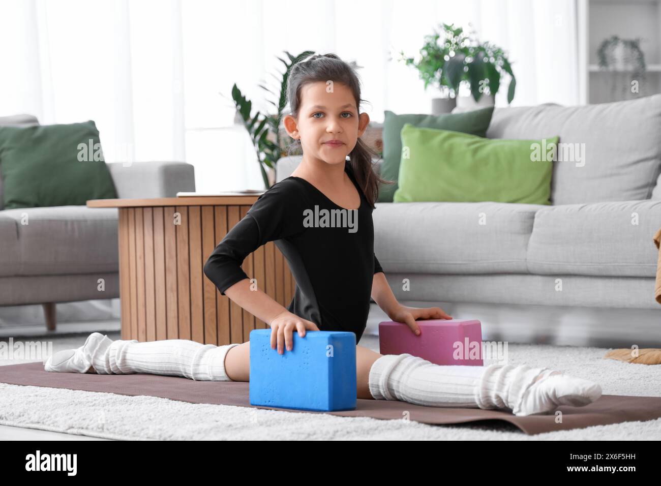 Little girl with blocks doing gymnastics at home Stock Photo - Alamy
