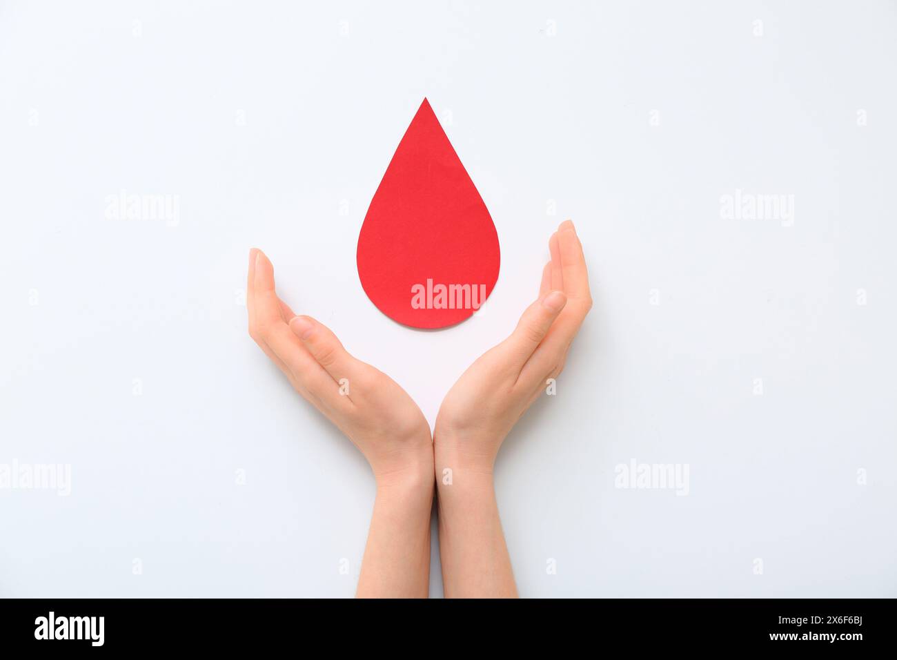 Female hands with paper blood drop on white background. World Blood ...