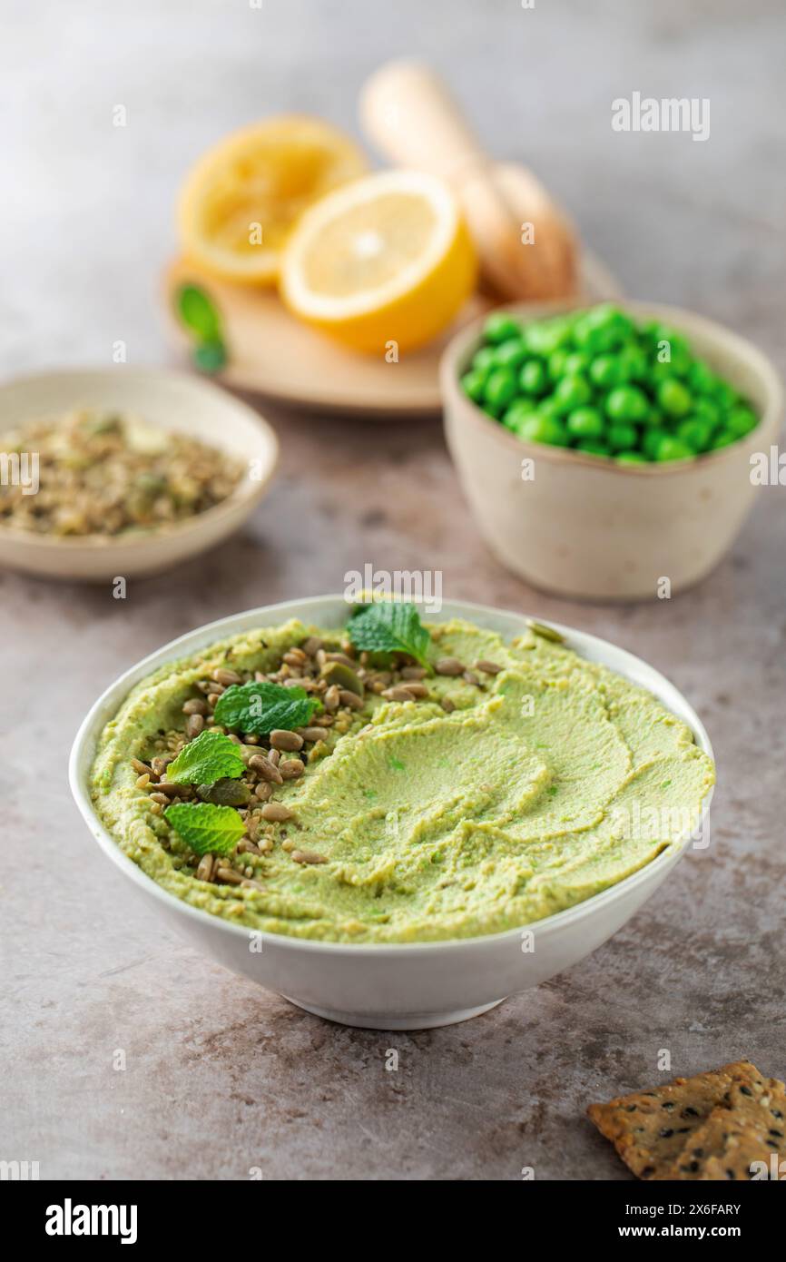 Hummus made of chickpeas, fresh green peas and mint, sprinkled with ...