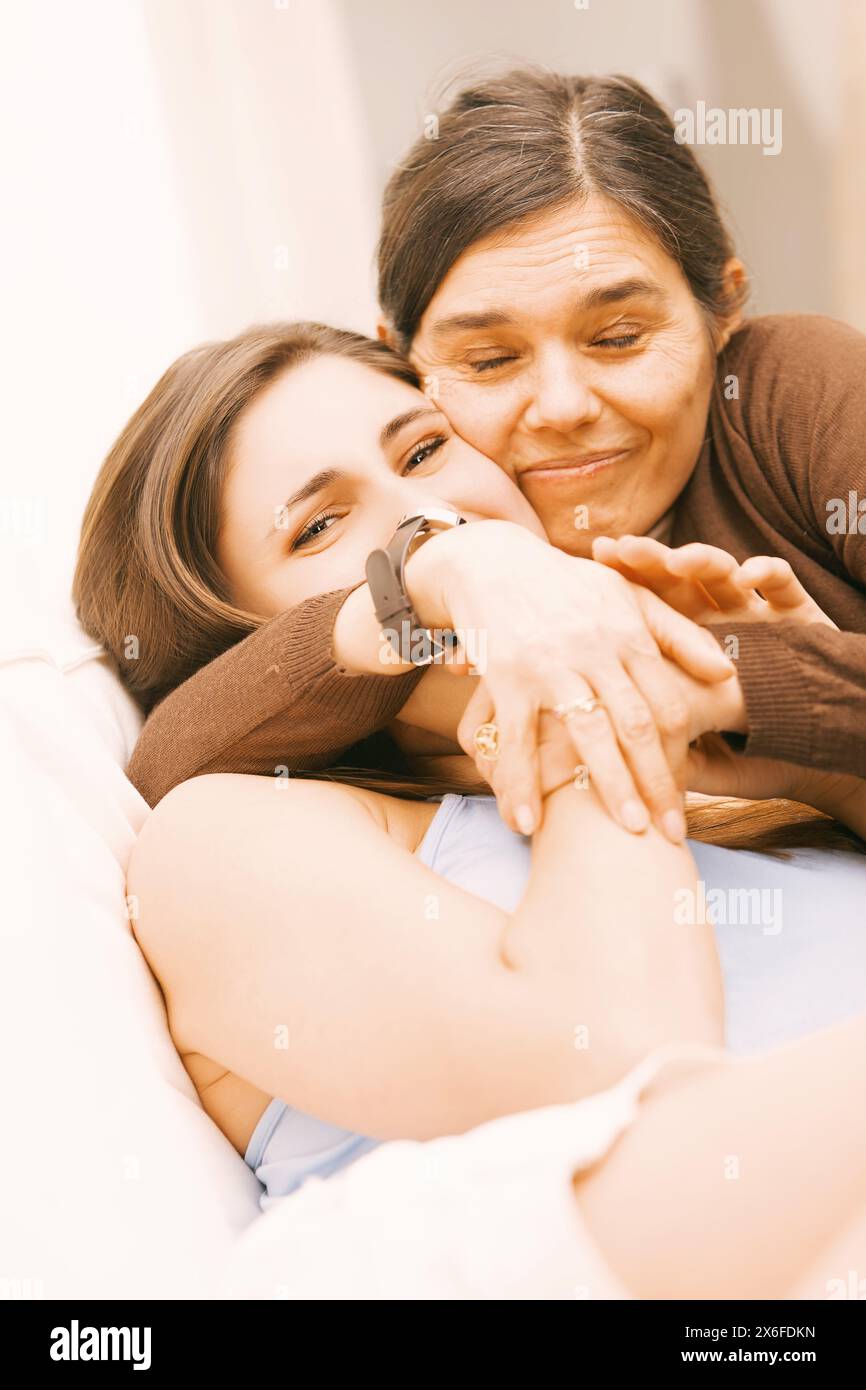 Serene maternal scene with a smiling woman and her serene daughter ...