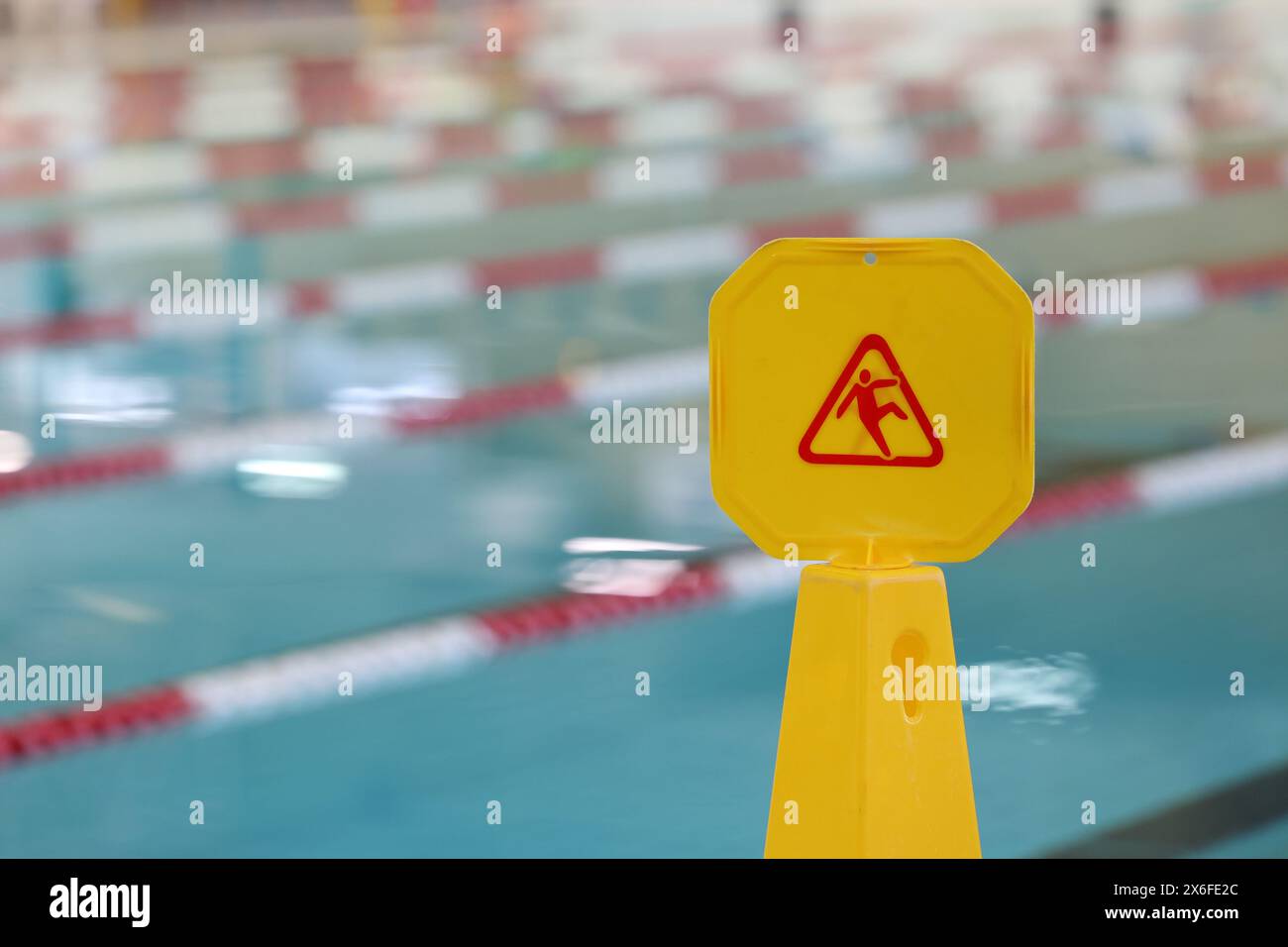 Yellow slip fall hazard sign at a public swimming pool. Public ...