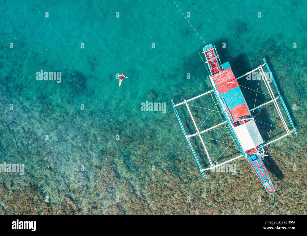 Aerial View of a Woman in Red Swimsuit Floating Serenely on the Crystal ...