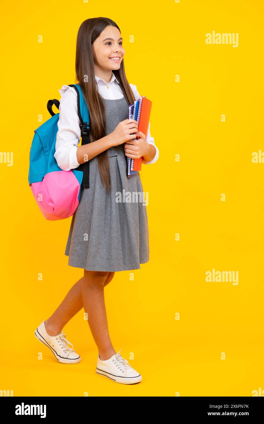 Back to school. Schoolgirl student hold book on yellow isolated studio ...