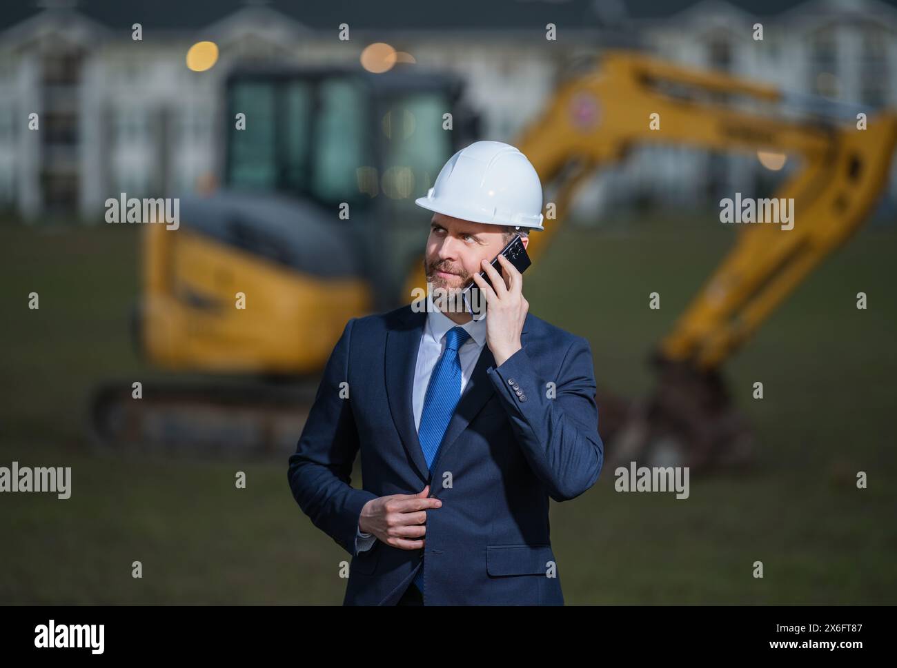 Construction owner near excavator. Confident construction owner in ...