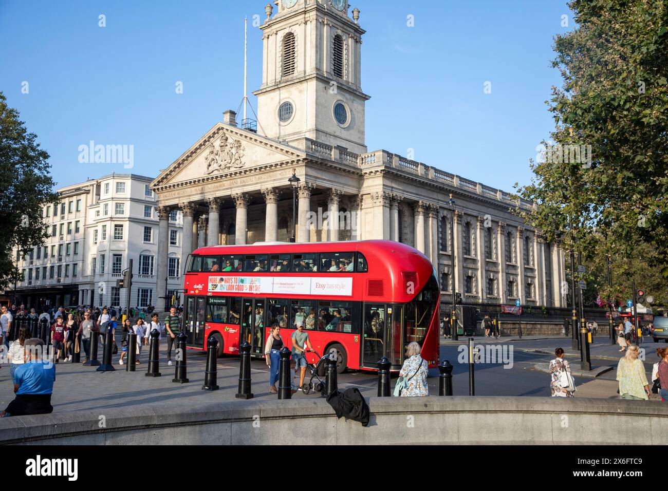Red London double decker bus in Trafalgar Square passing St Martin in ...
