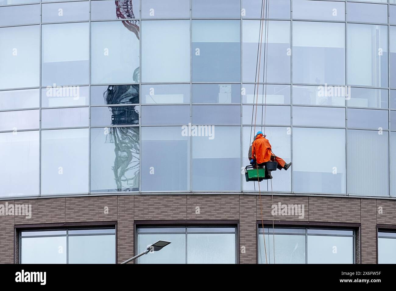 St. Petersburg, Russia - May 10, 2024. An industrial climber washes the ...