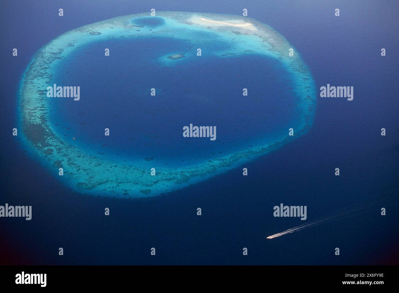 View of boat passing coral atoll from helicopter, taken in 1997 ...