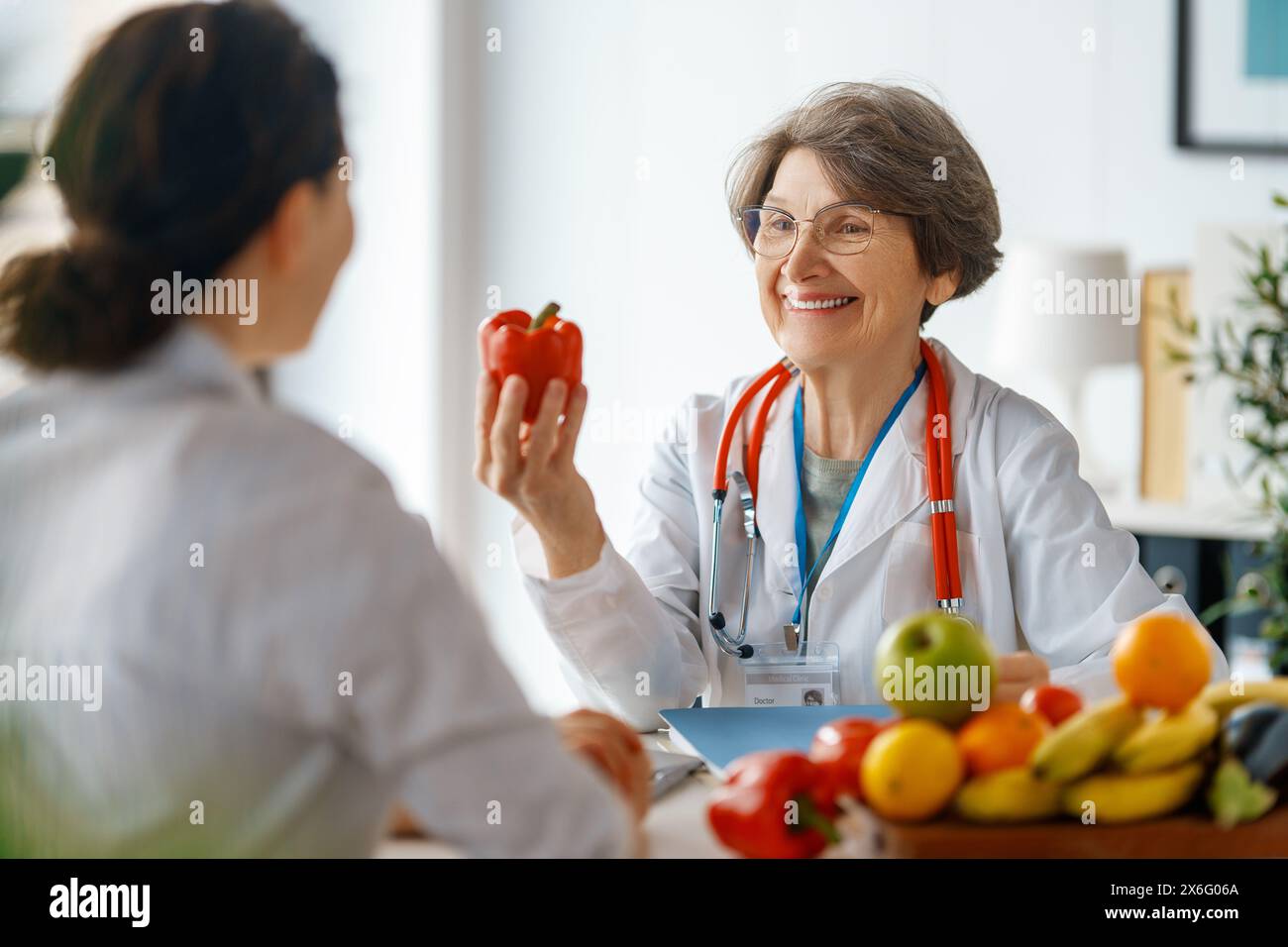 Happy doctor is working in medicine office. A woman is talking to a ...