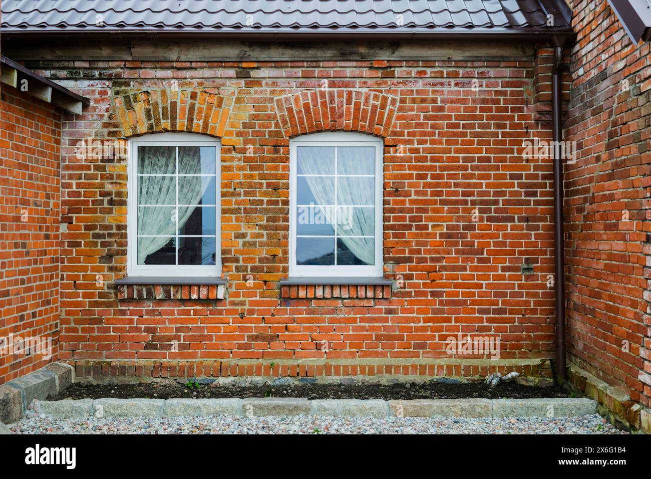 The brick building features two windows on its side, showcasing the ...