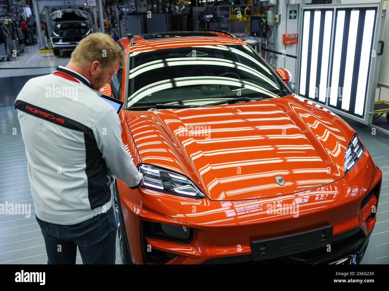 Leipzig, Germany. 06th May, 2024. A Porsche employee checks an all ...