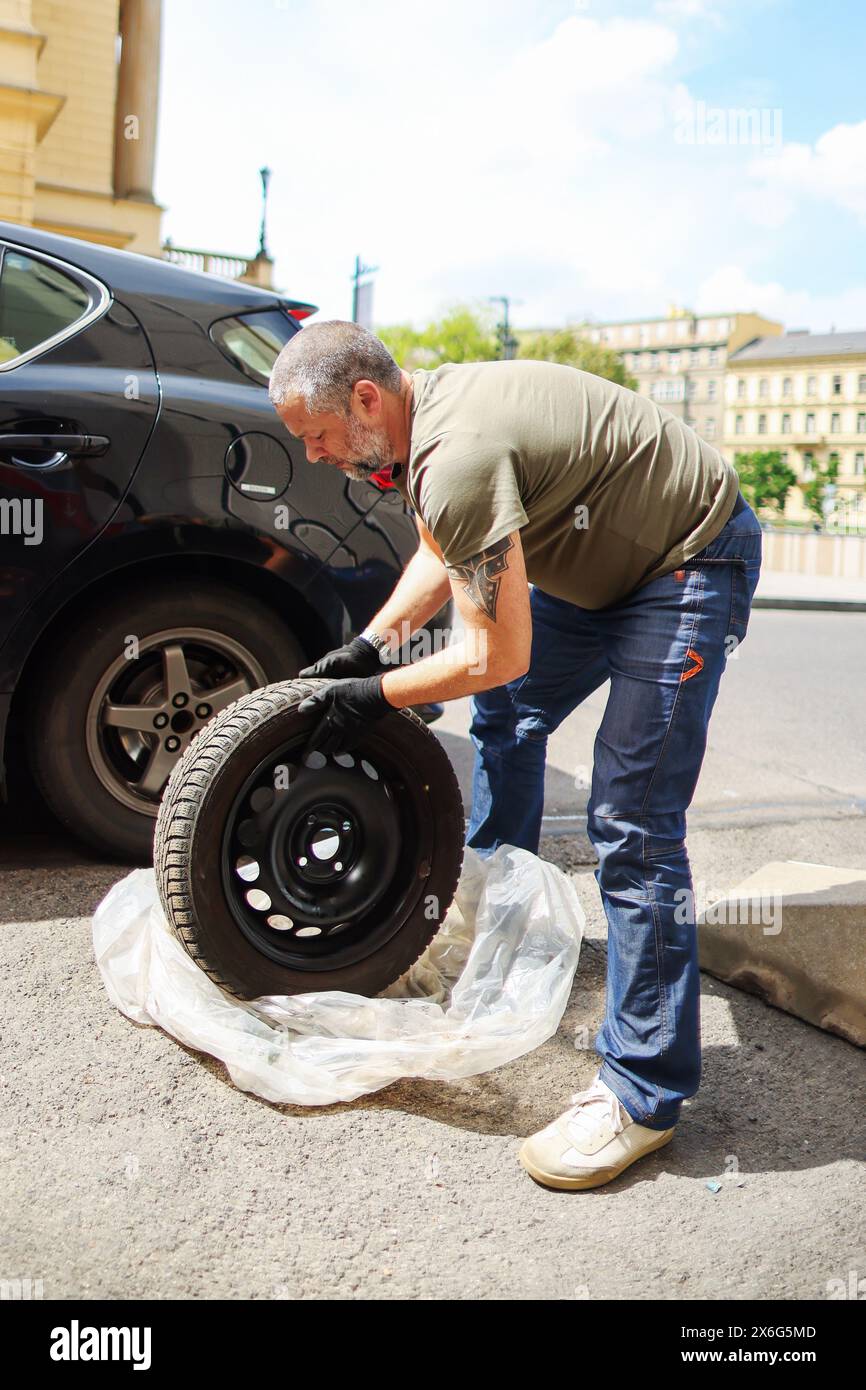 Auto mechanic changing tire on car on road Stock Photo - Alamy