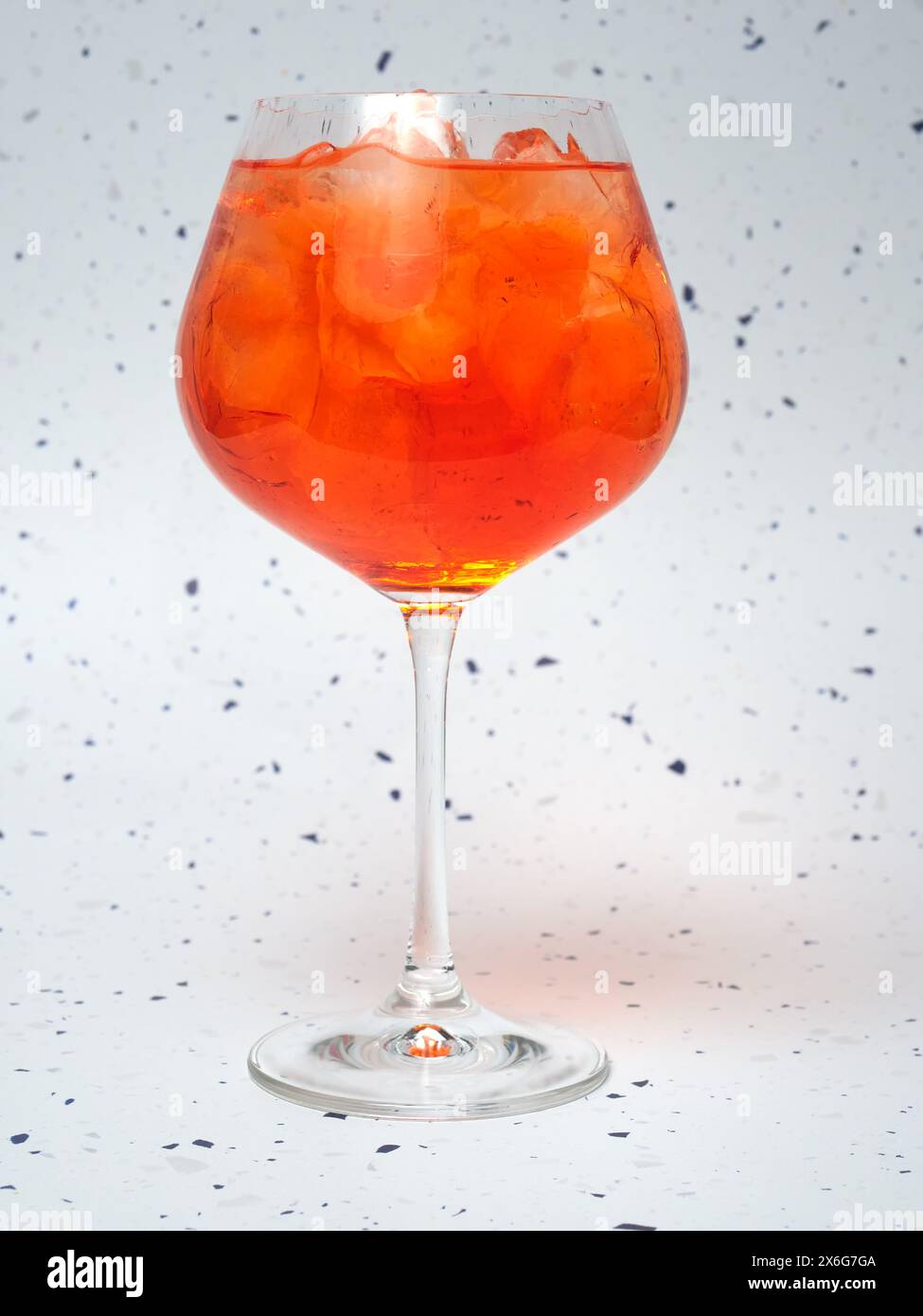 A close-up of a chilled Aperol Spritz filled with ice cubes. The ...