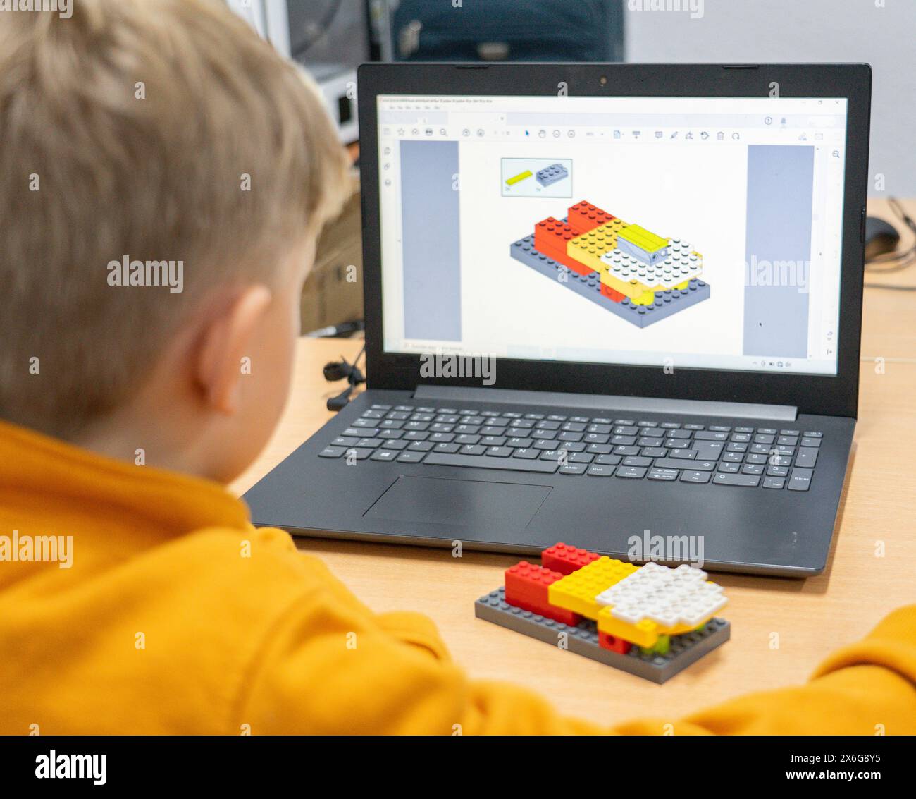 Boy in robotics class learning to make a robot with construction pieces ...