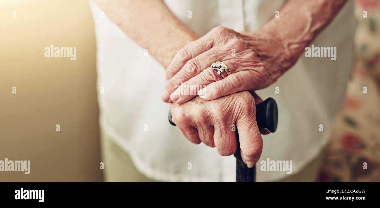 Hands, walking stick and closeup with senior woman, injury and disabled with balance in ...