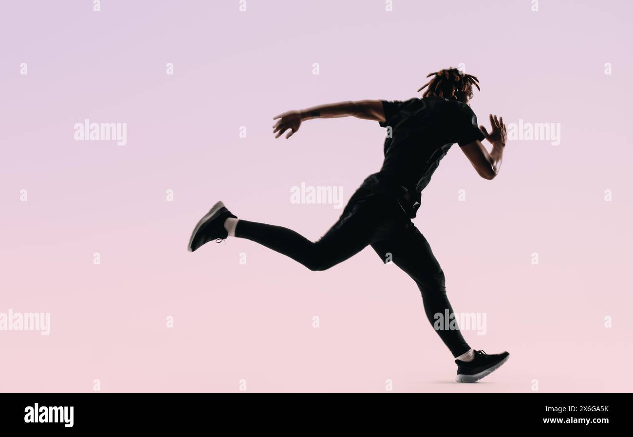 Athletic man sprints in silhouette on a pink background. His form and ...