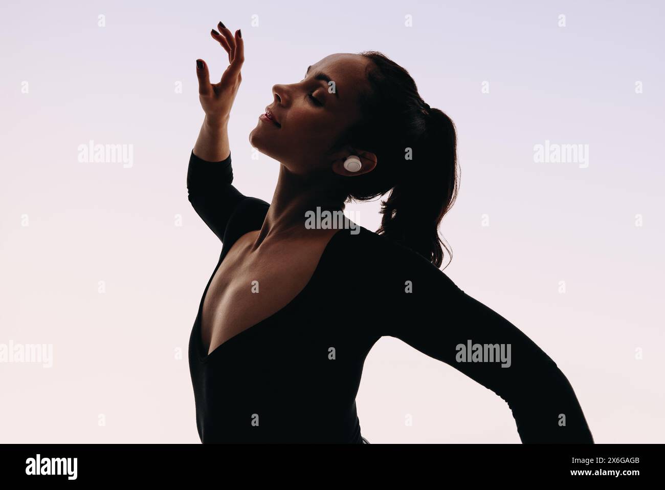 Elegant female performer with a toned physique dances to music with ...