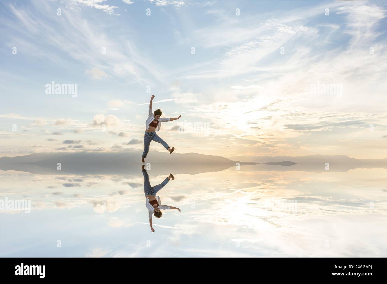 woman on the beach dancing at sunset in backlight with the sun behind ...