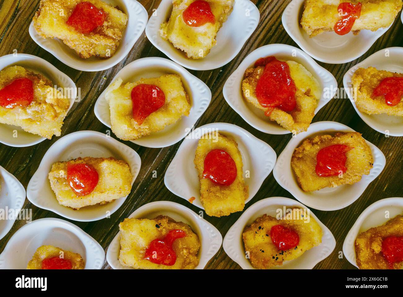 Elegant presentation of fried bites with red sauce, arranged on small ...