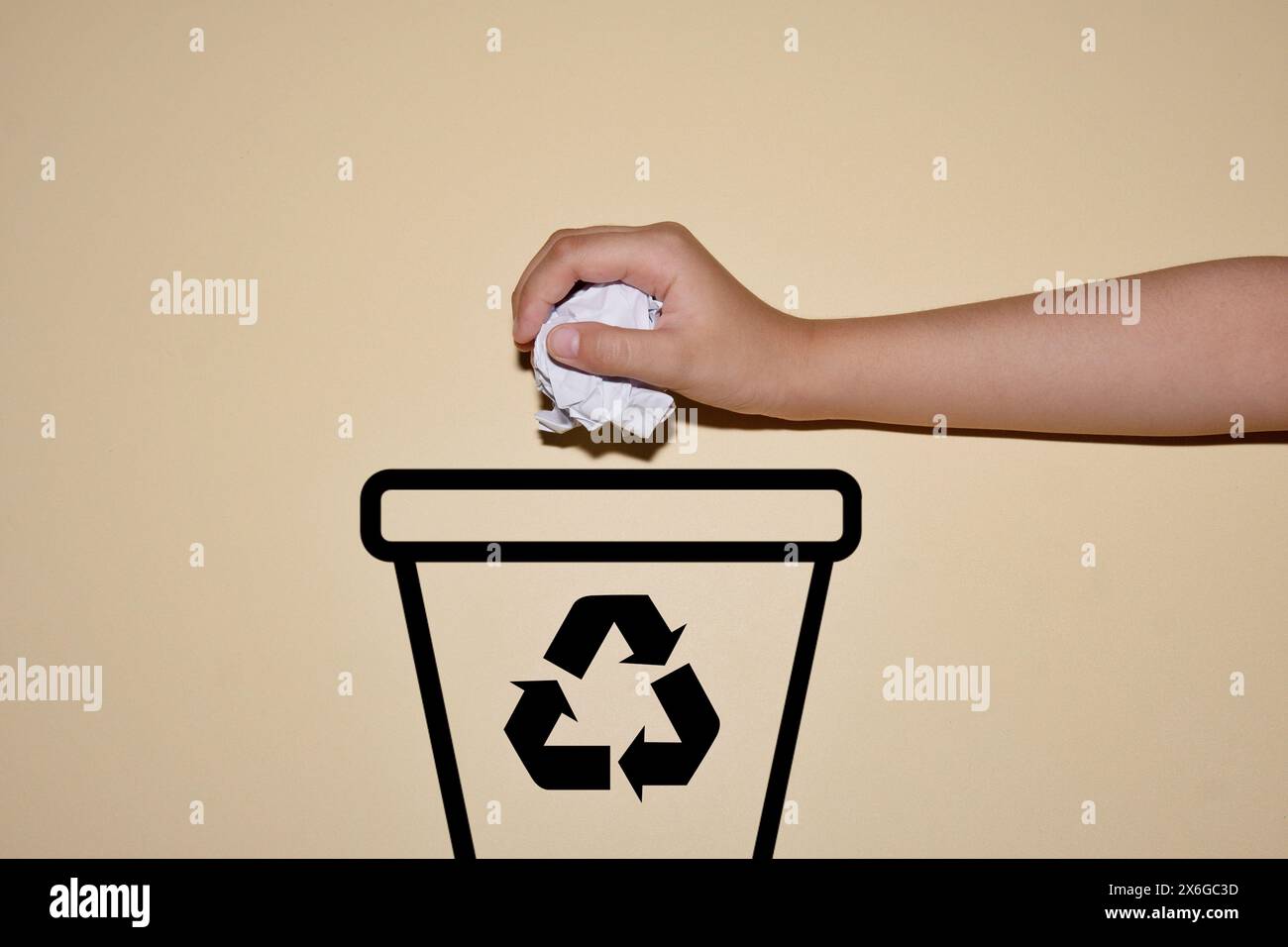 Hand throwing crumpled paper into dustbin with recycling symbol ...