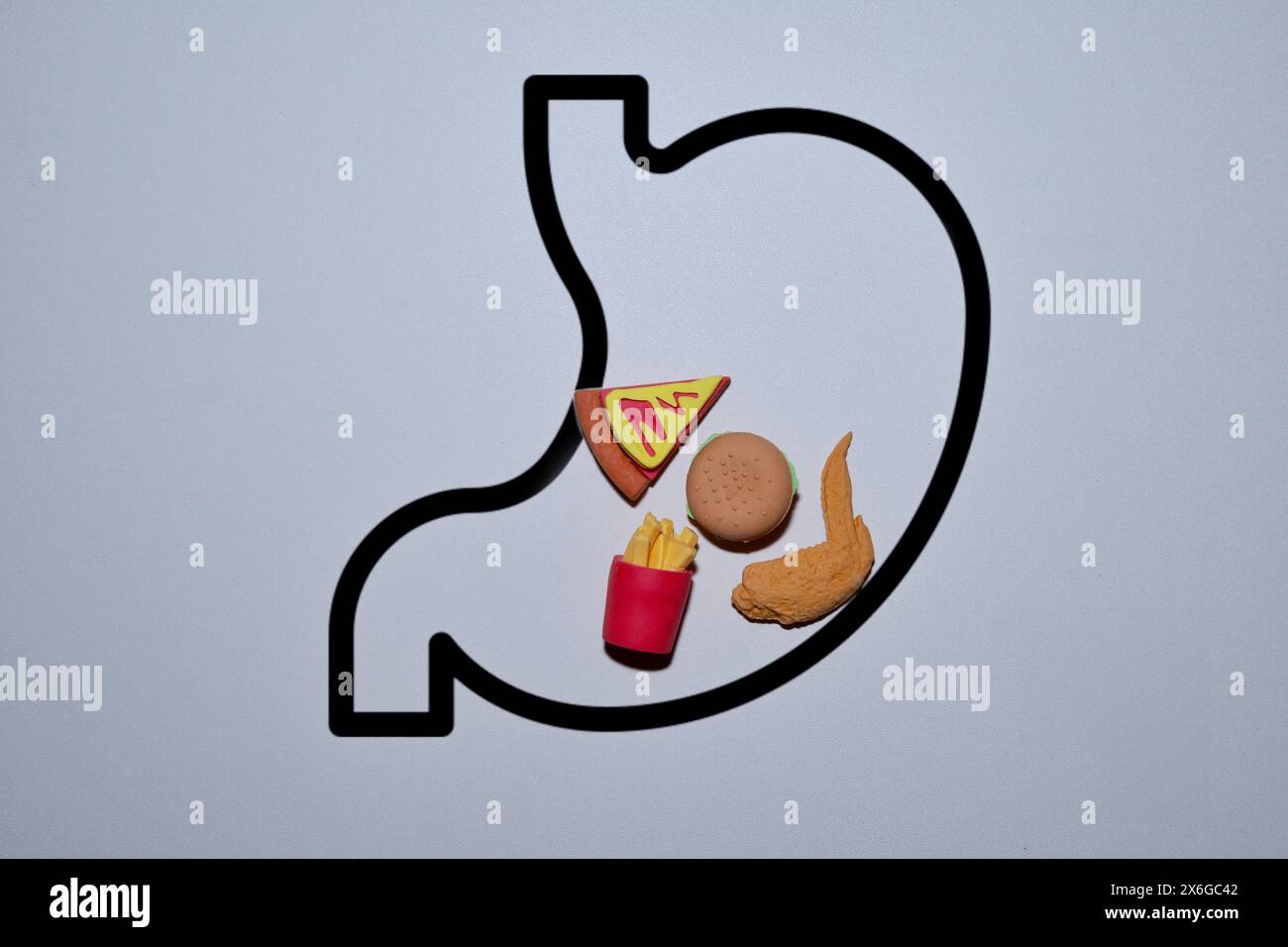 Conceptual image of full stomach with a variety of fast food like pizza ...
