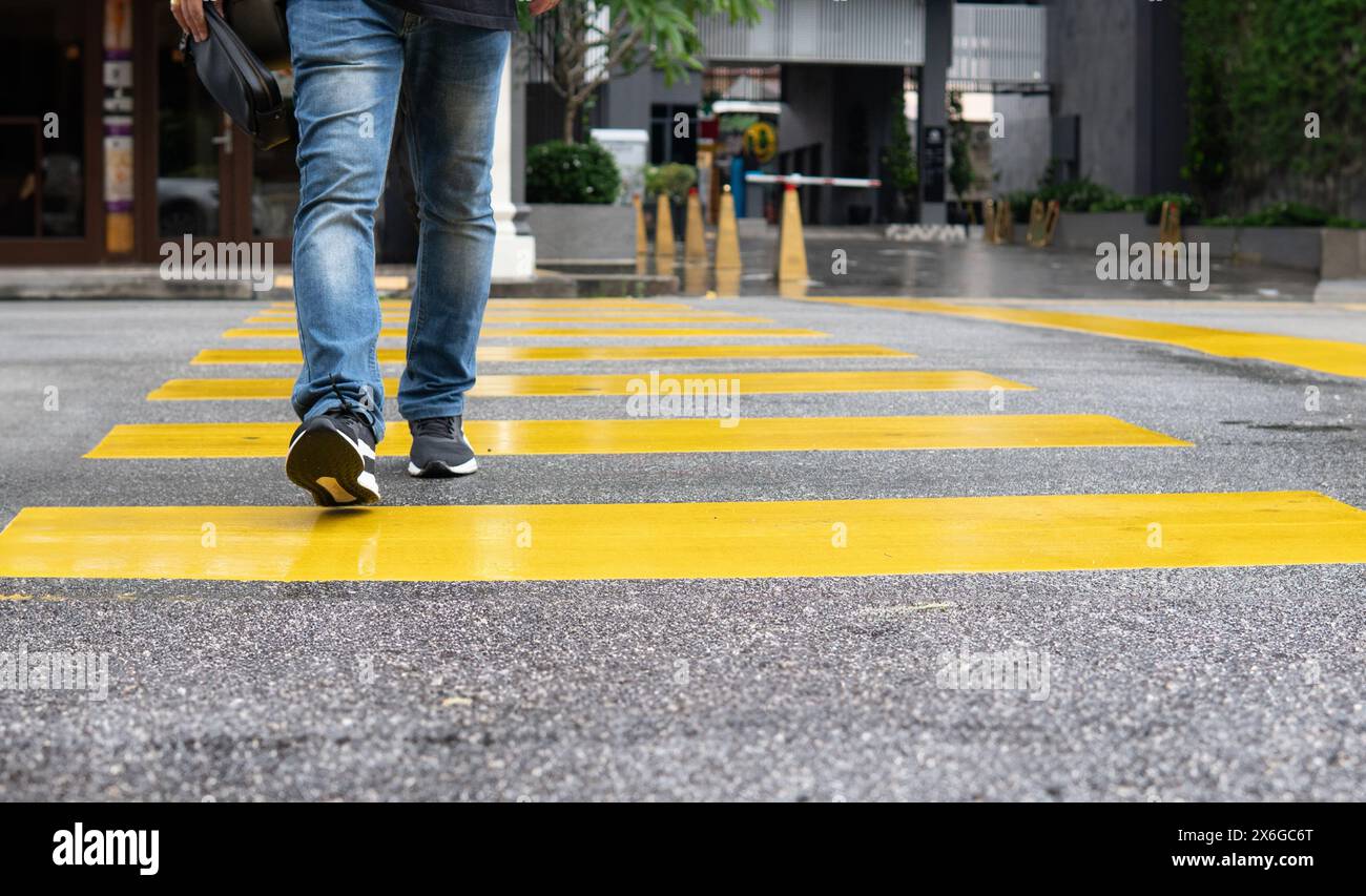 Man crossing the road using yellow zebra crossing. Road traffic safety ...