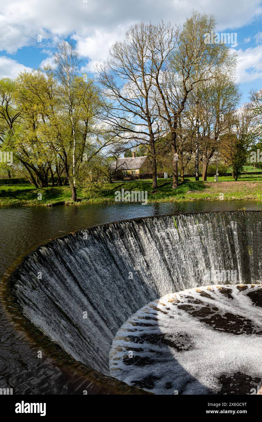 Water flows from a small semi-circular dam in a small village by the ...