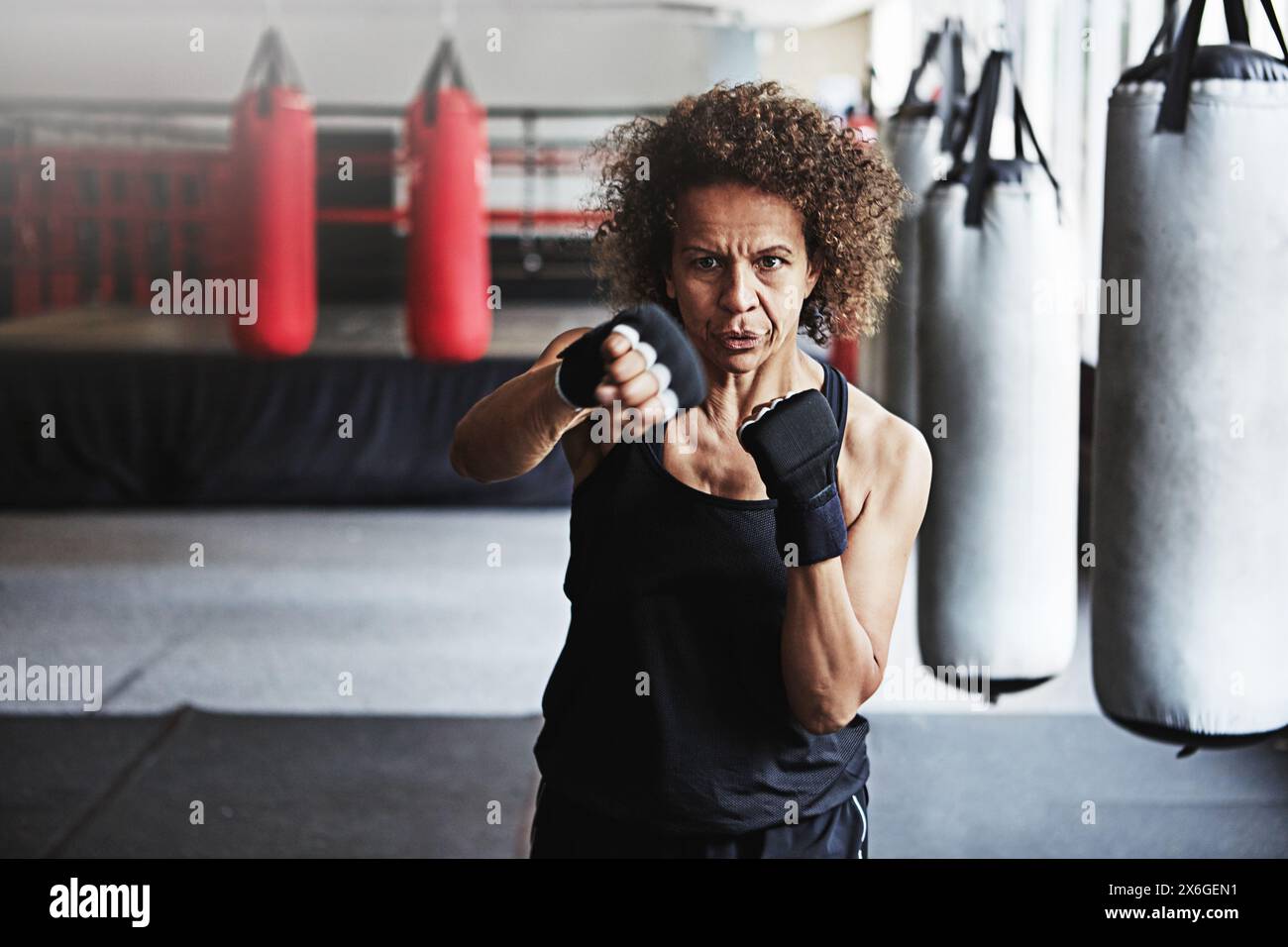 Fitness, punching and mature woman in gym for exercise, boxing ...