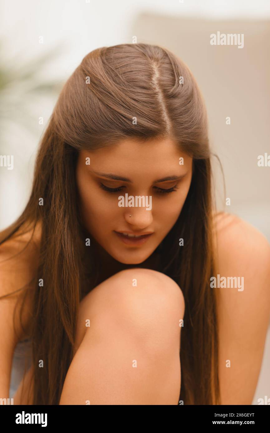 Captured in an introspective moment, this young woman, focused downward ...