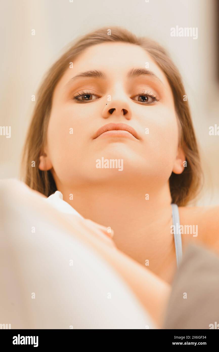 Her eyes slightly narrowed, this young woman's face conveys a skeptical ...
