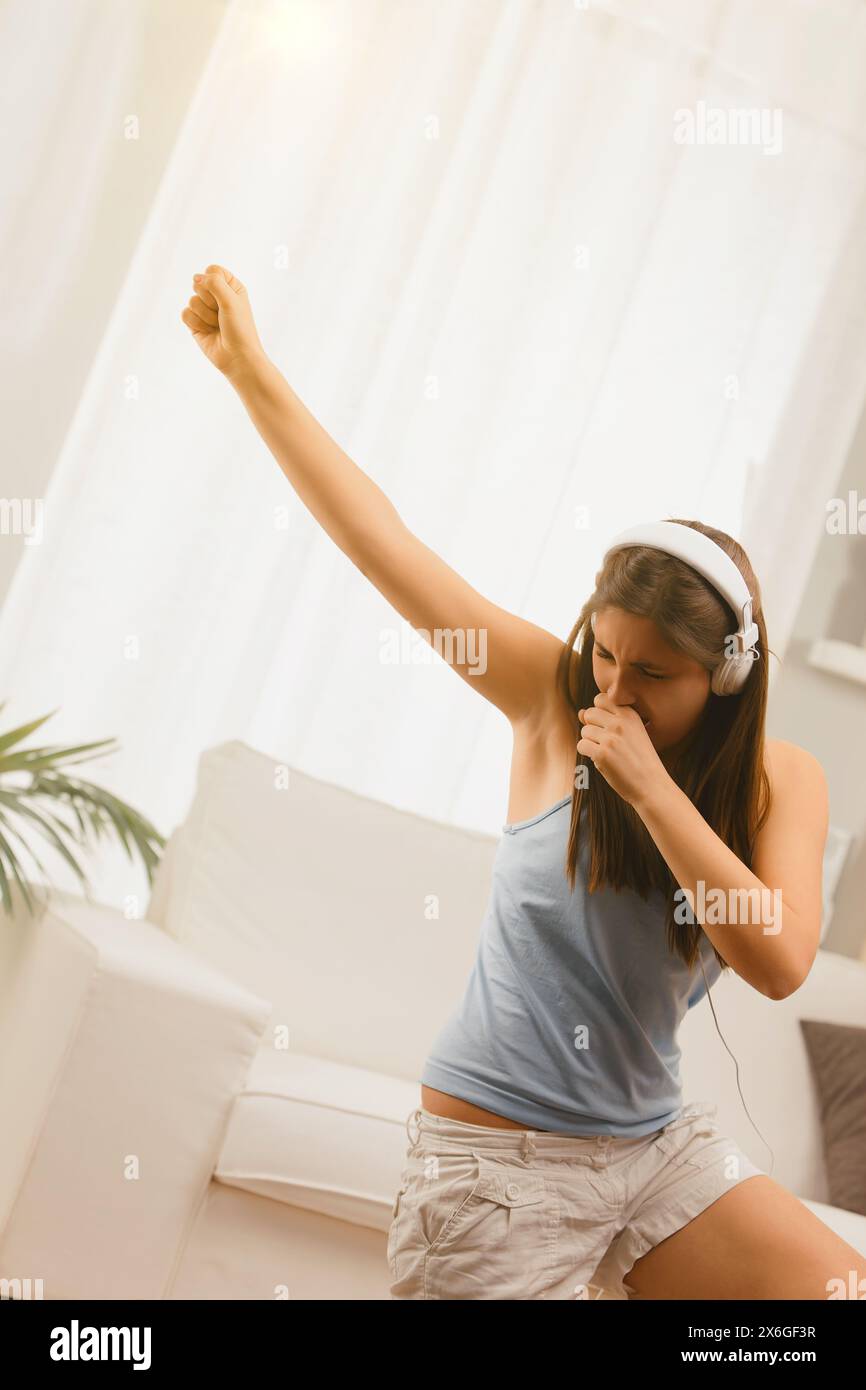 Enjoying the music fully, this young woman exhibits a lively dance move ...